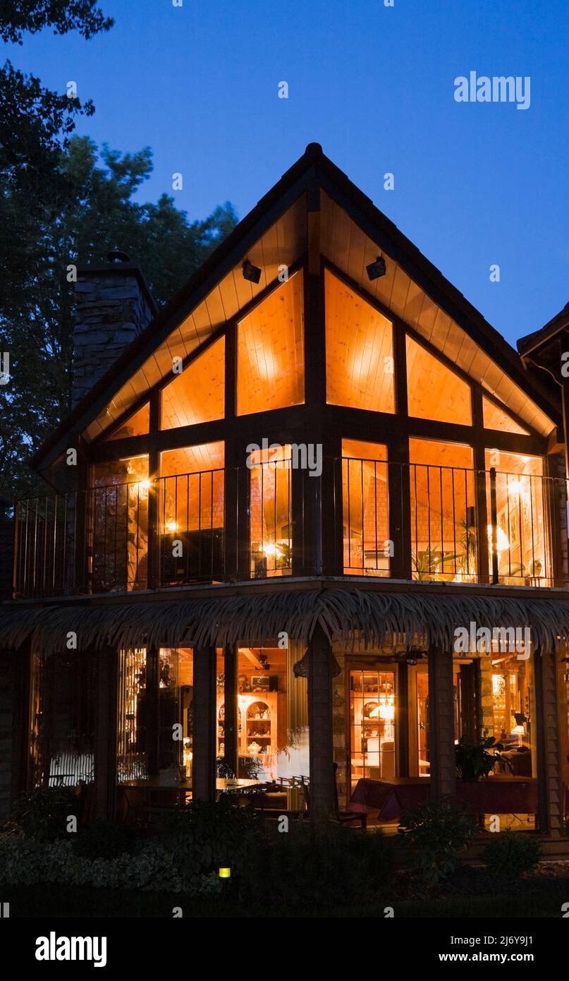 Rear view of modern tropical timber frame style home at dusk Stock ...
