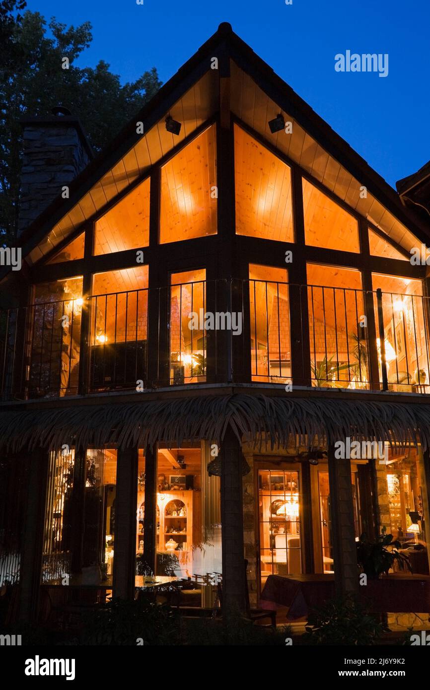 Rear view of modern tropical timber frame style home at dusk Stock ...