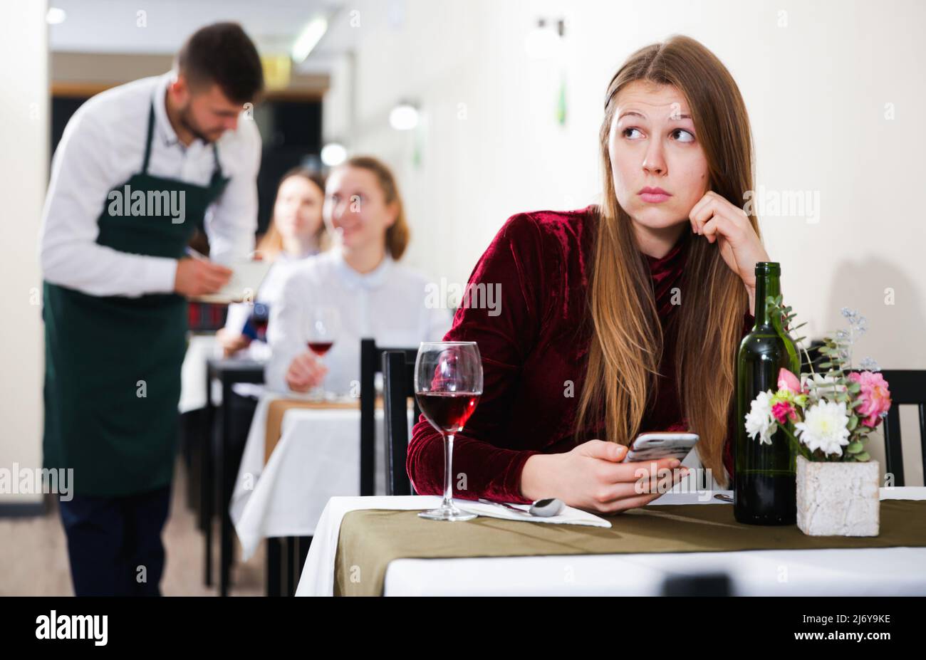Young female is having dinner alone in the restaurante Stock Photo - Alamy