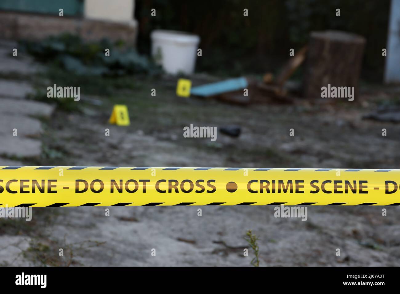 Crime scene tape for covering the area cordon. Yellow tape with blurred forensic law enforcement ...