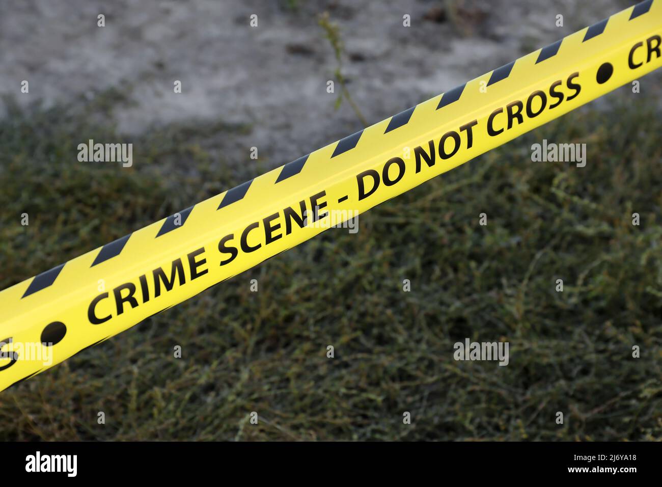 Crime scene tape for covering the area cordon. Yellow tape with blurred forensic law enforcement ...
