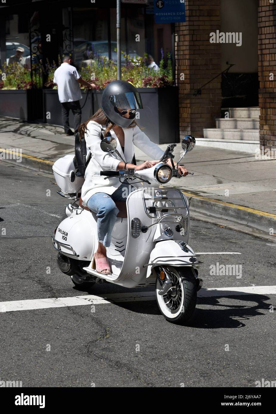 A woman riding a BMS Chelsea 150 scooter pauses at a light in San ...