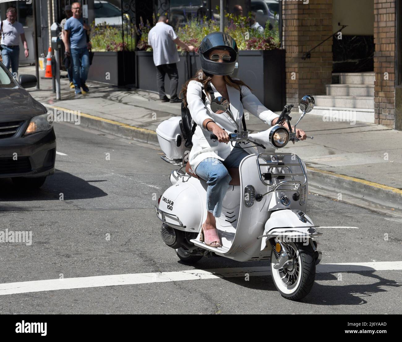 A woman riding a BMS Chelsea 150 scooter pauses at a light in San ...