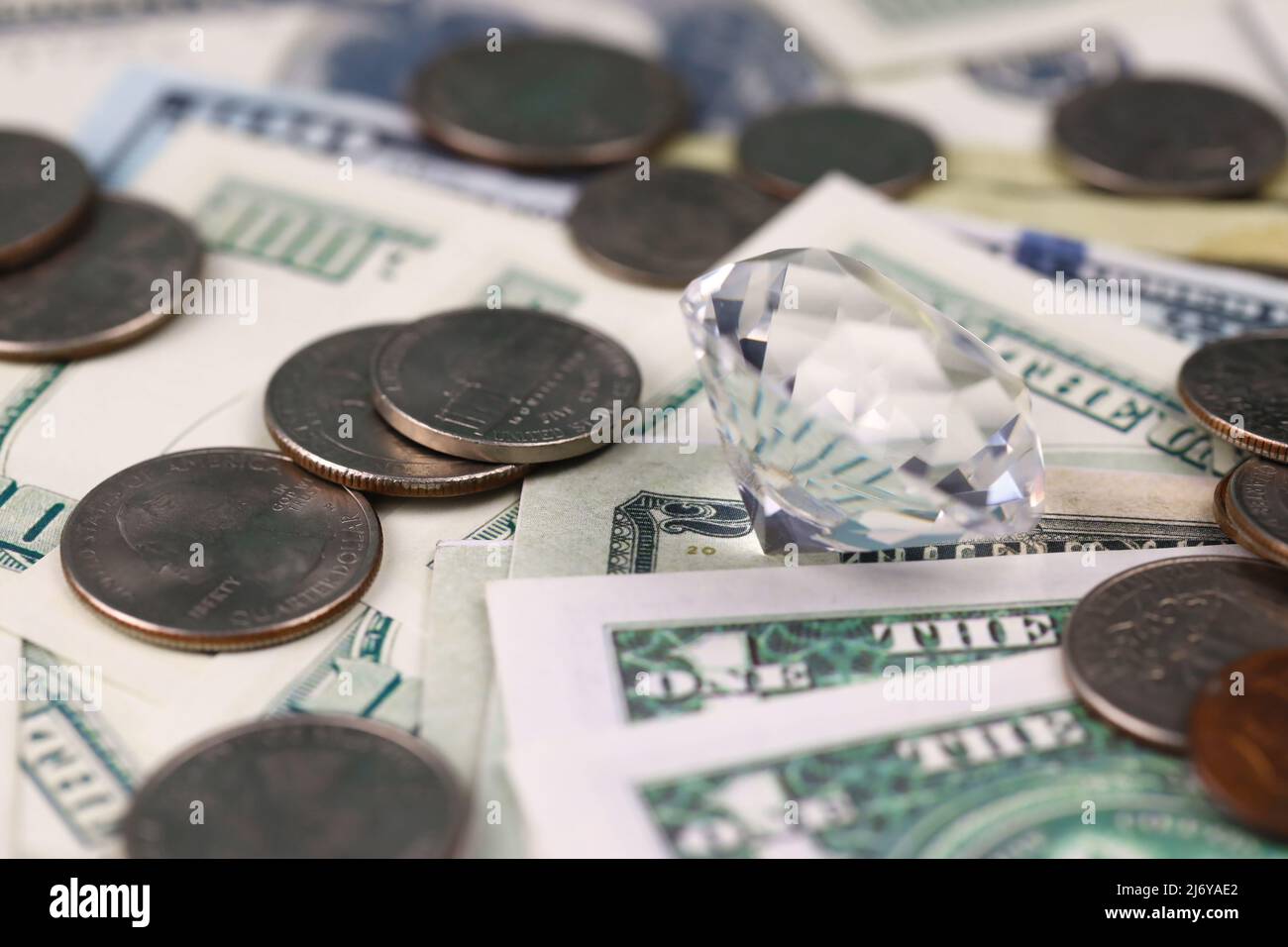 US money bills and coins with large diamond close up. Big amount of ...