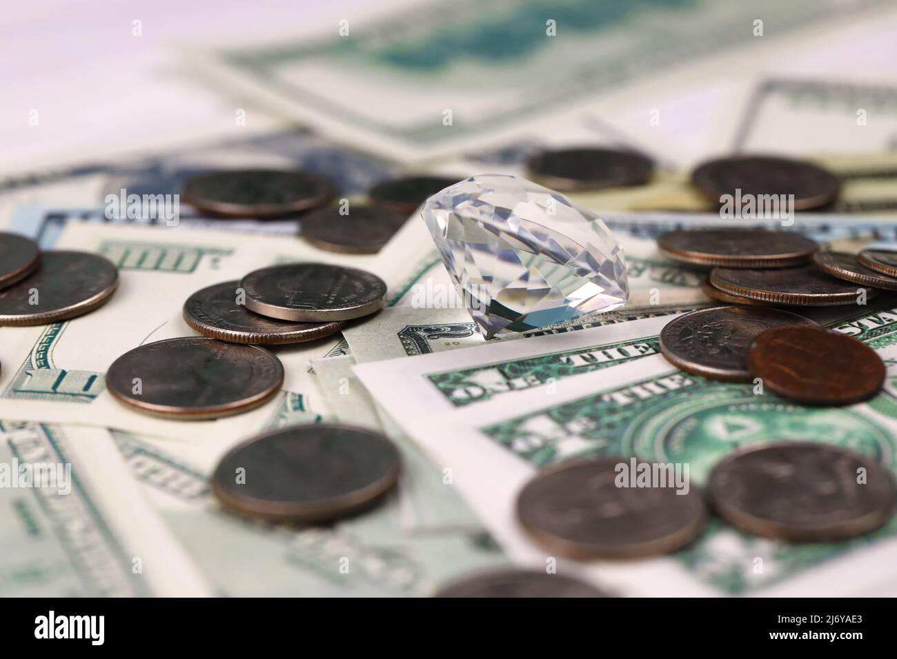 US money bills and coins with large diamond close up. Big amount of ...