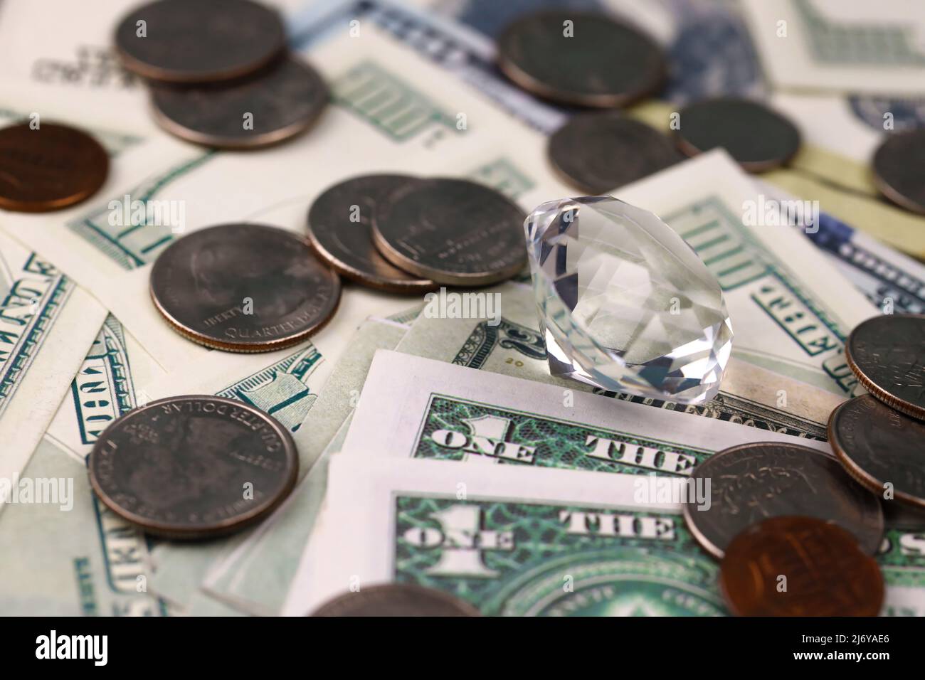 US money bills and coins with large diamond close up. Big amount of ...