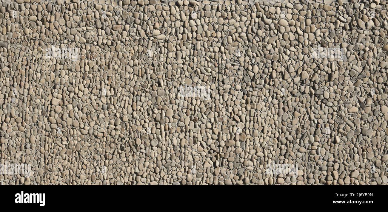 Texture of a stone wall with small round pebble stones. Part of a stone ...