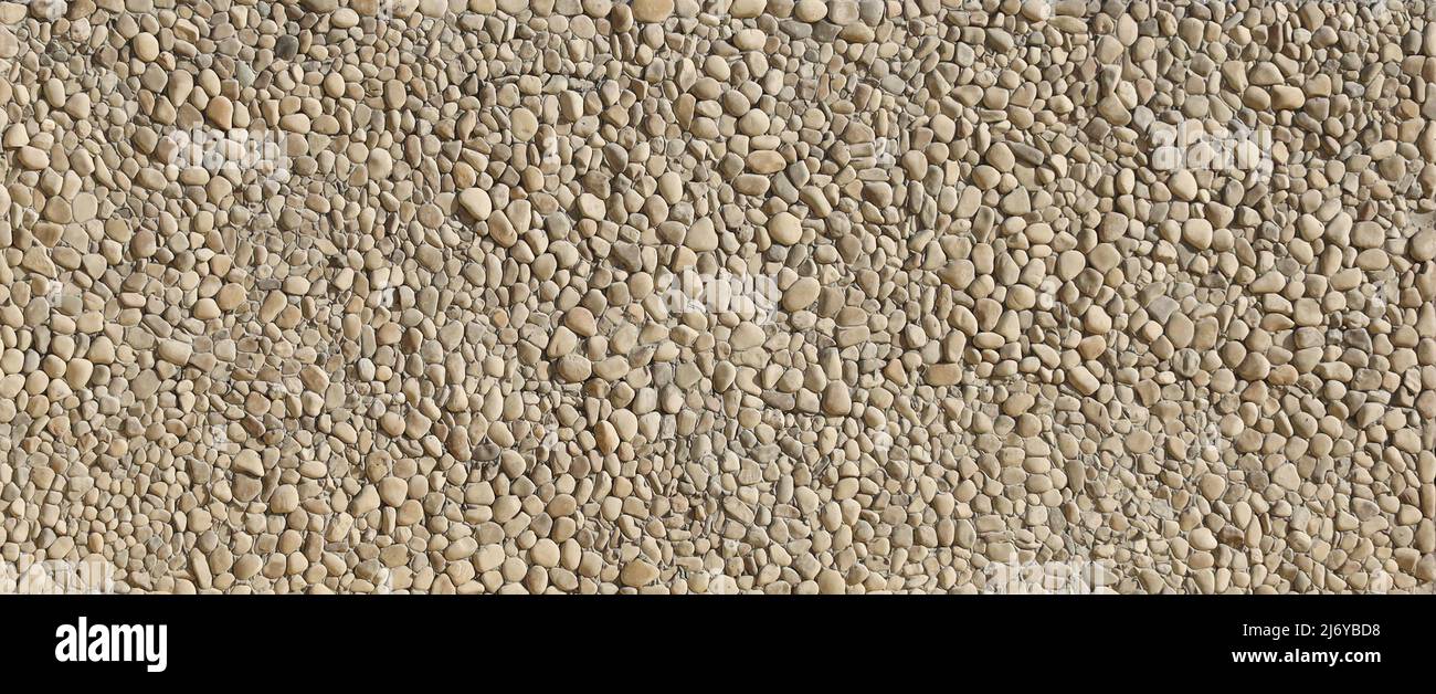 Texture of a stone wall with small round pebble stones. Part of a stone ...