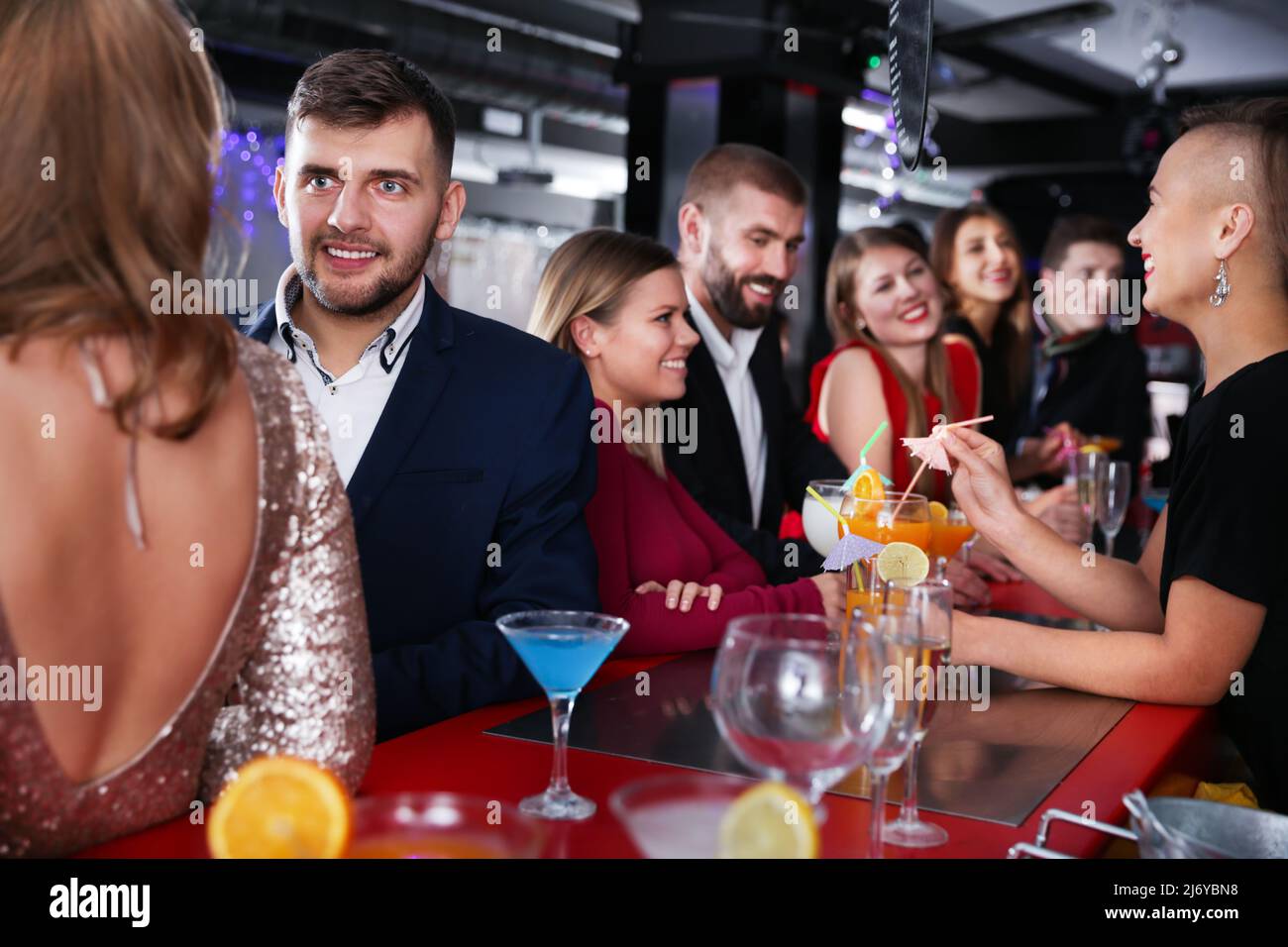 Friendly colleagues partying in bar and toasting drinks Stock Photo - Alamy