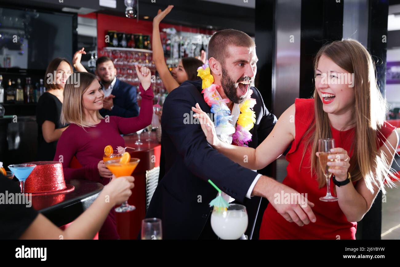 Guy flirting with girl on Hawaiian party at nightclub Stock Photo - Alamy