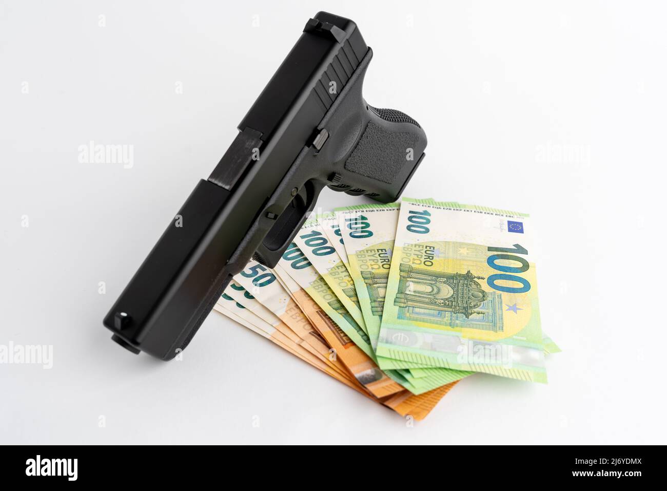 Gun and Euro banknotes on a white background. Symbols of crime in the ...