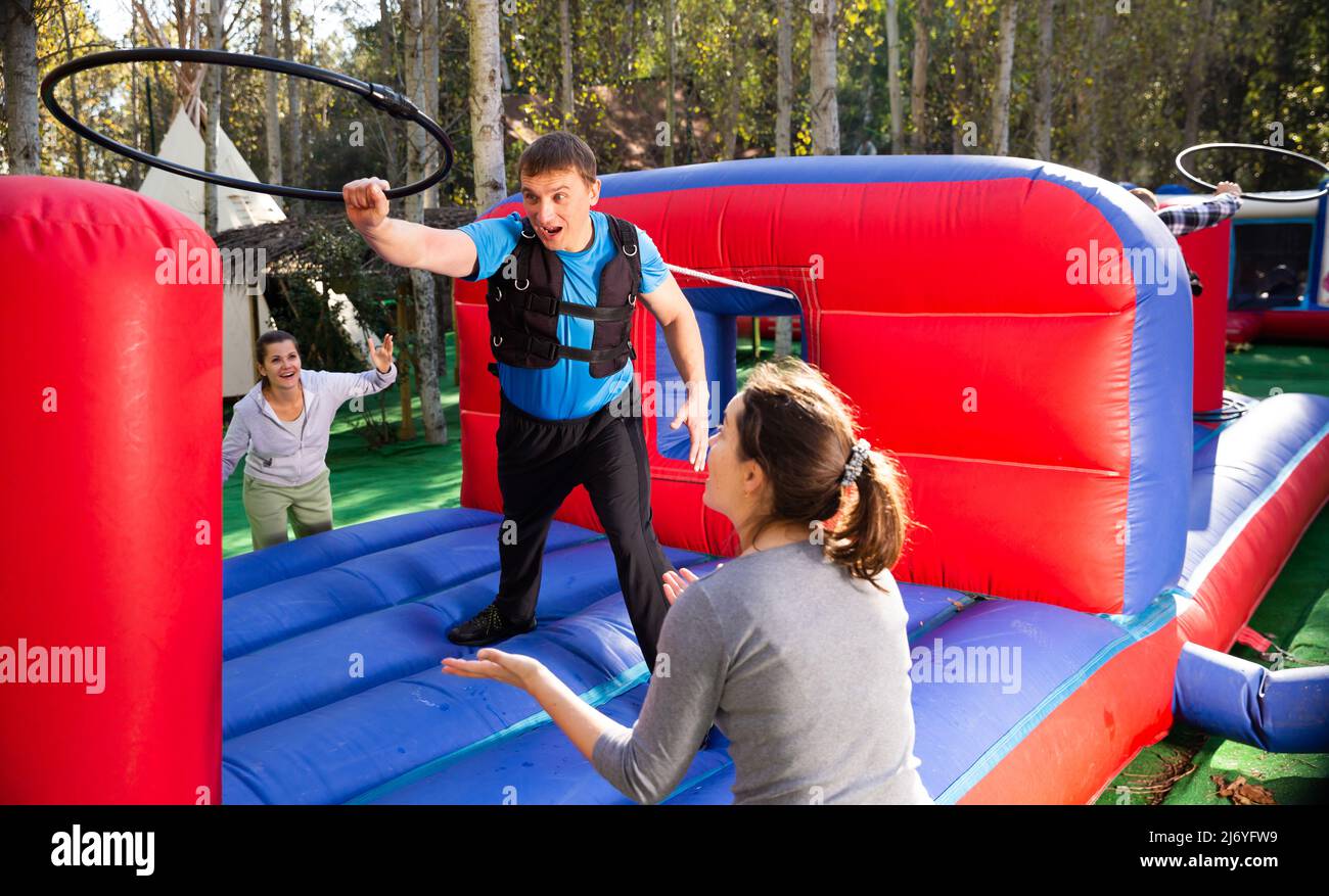 Men competing to collect hoops on inflatable arena Stock Photo - Alamy