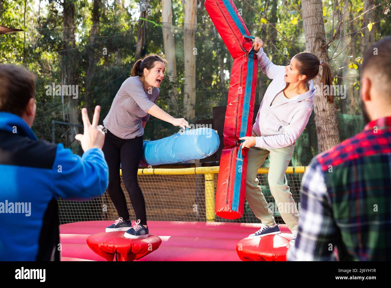 Female friends fighting by inflatable logs Stock Photo - Alamy