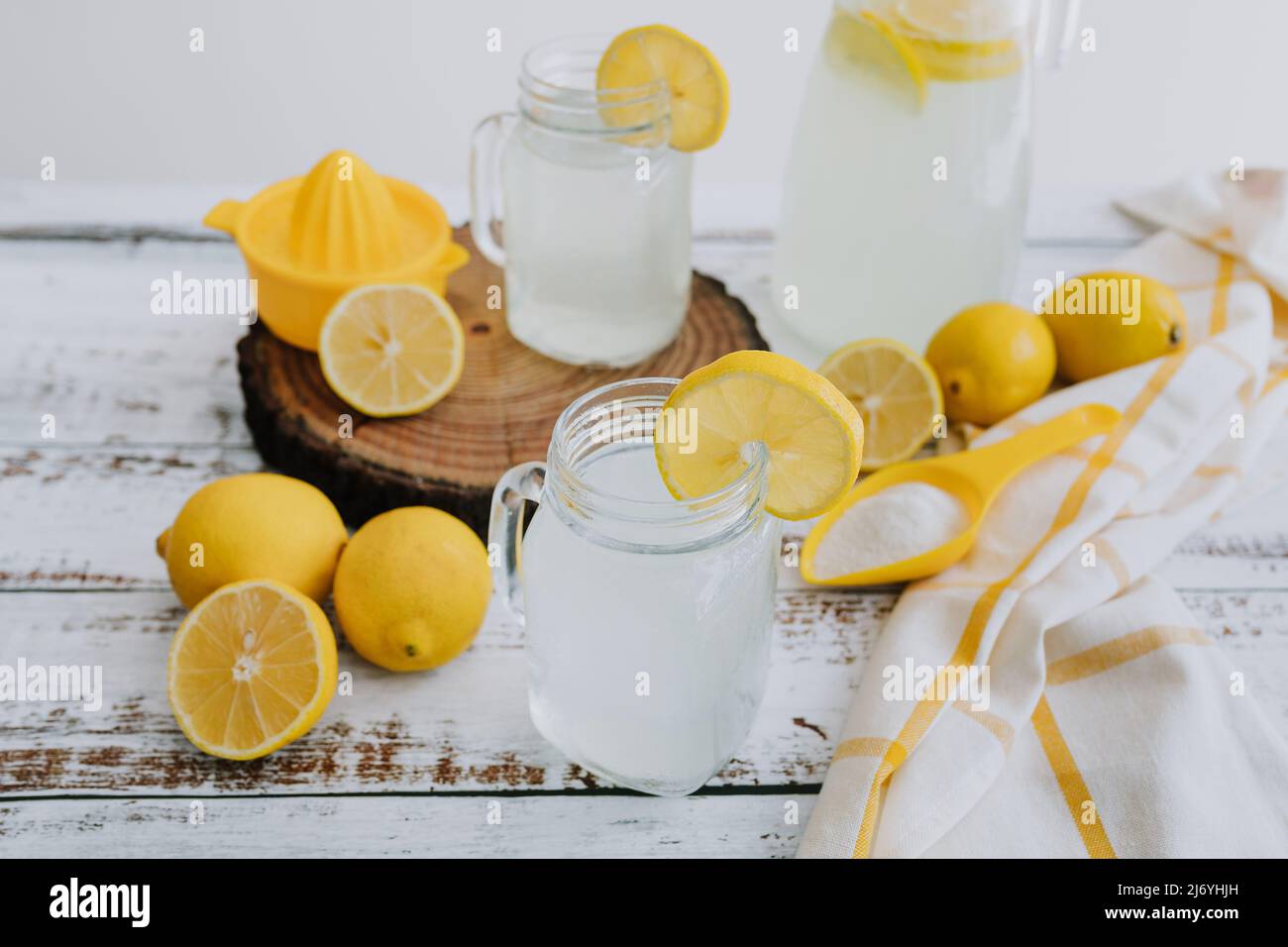 Jar glass of lemonade drink with yellow lemons or lime on a white ...
