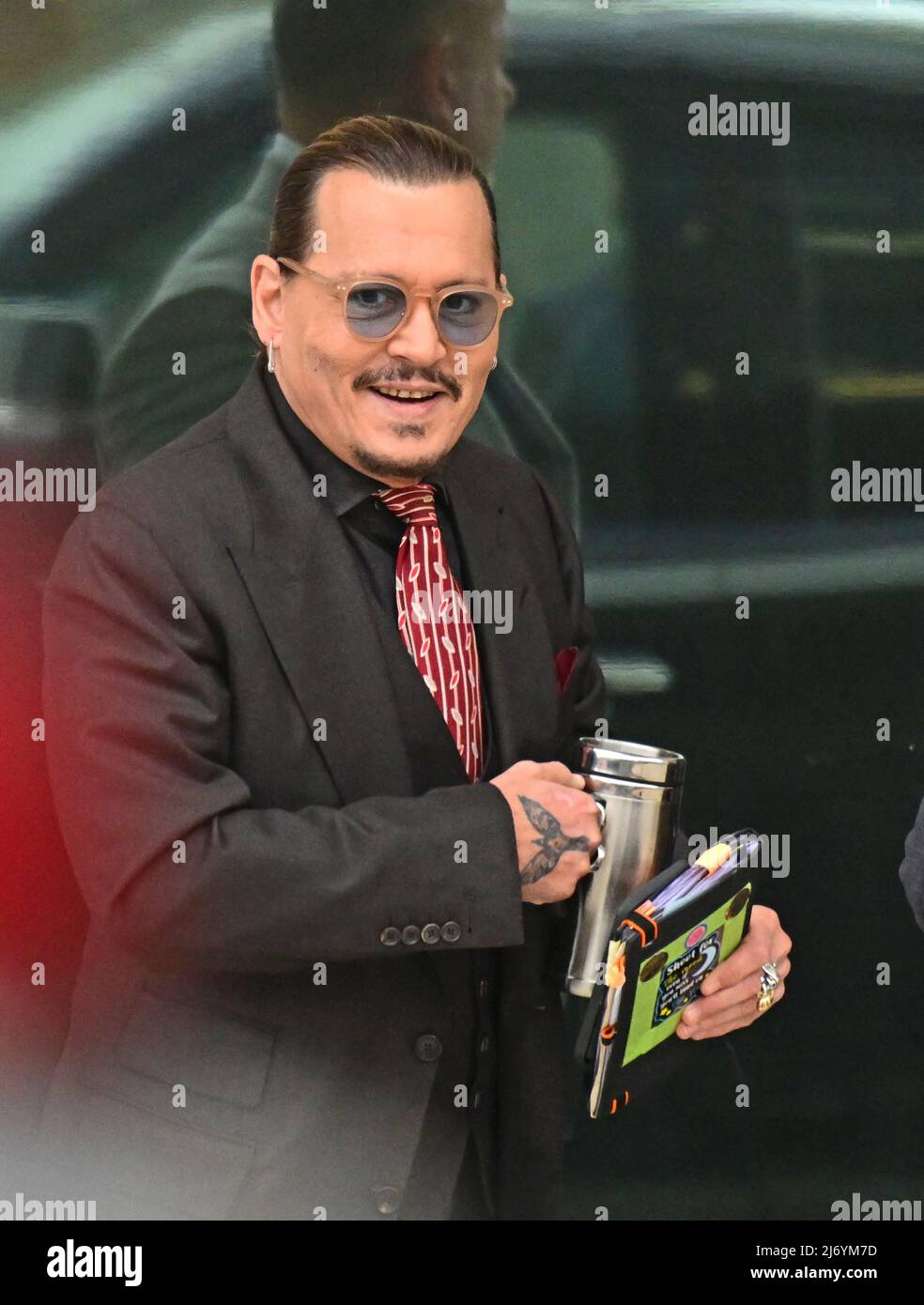Johnny Depp smiles as he arrives at the Fairfax County Courthouse, in ...