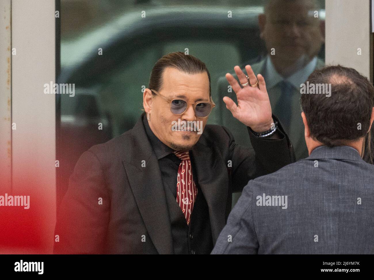 Johnny Depp waves to his fans as he arrives at the Fairfax County ...