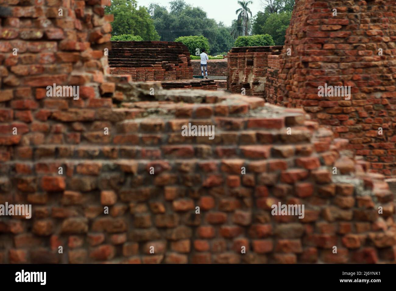 A visitor is photographed through ruins of brick structures at Dhamek ...