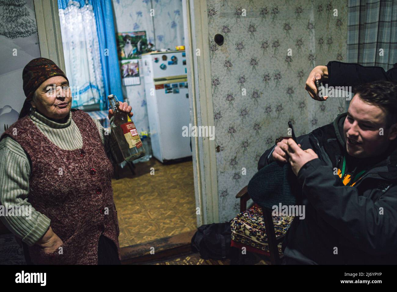 An elderly inhabitant of the Chernobyl exclusion zone shows tourists ...