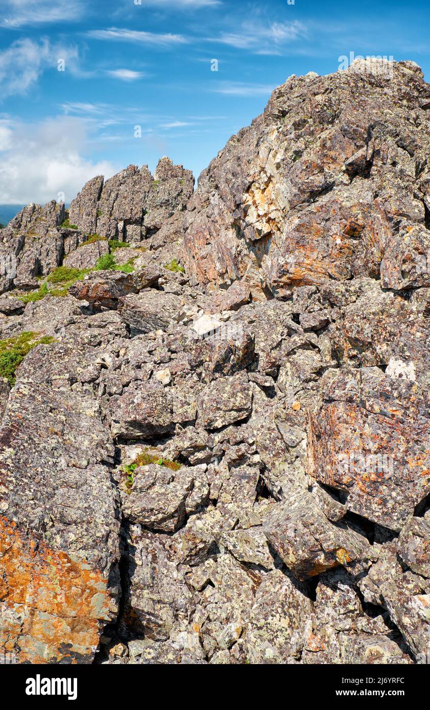 Stones on the mountainside under blue sky and clouds background ...