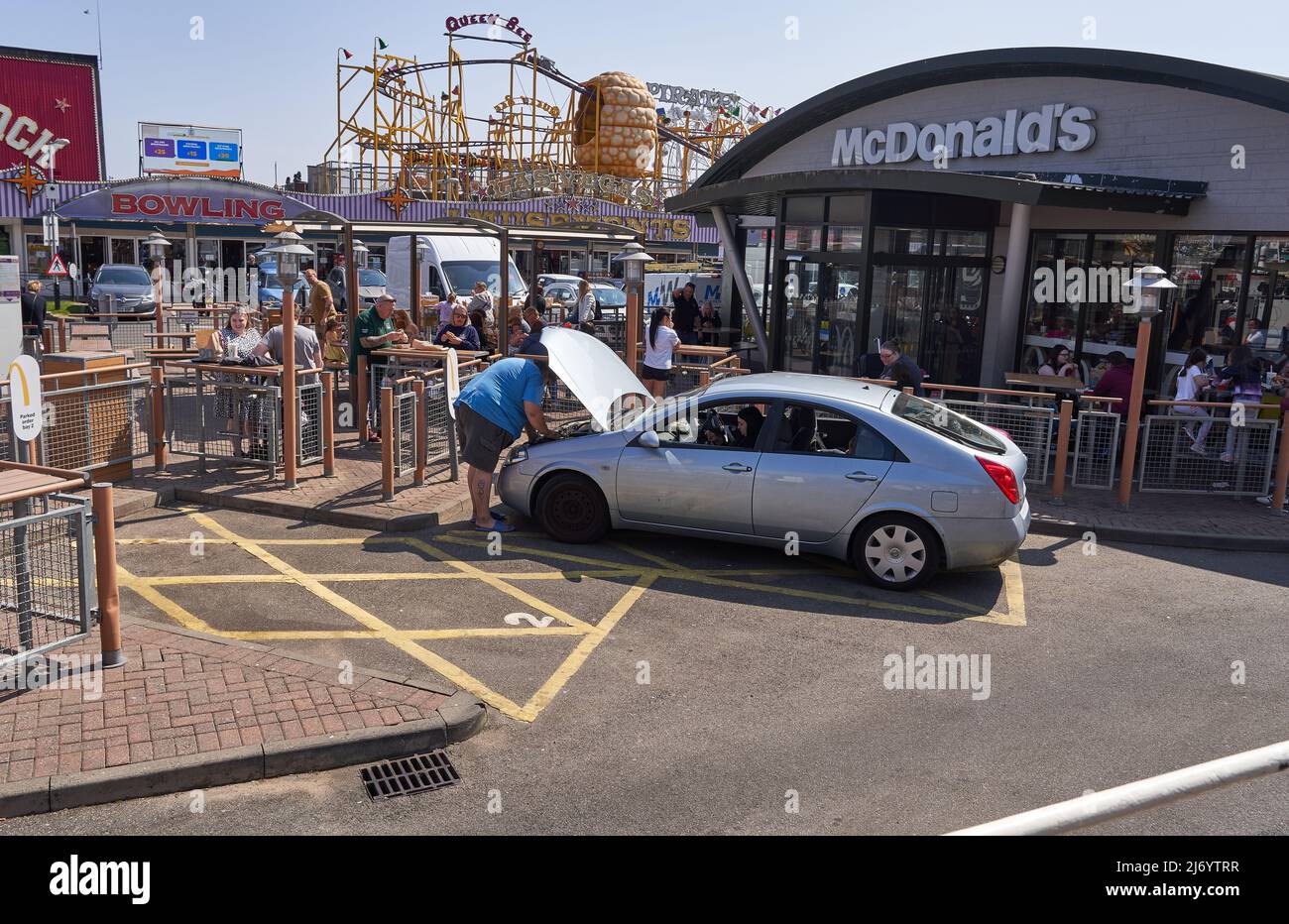 Fat man looking at a car engine in a drive thru car park Stock Photo ...