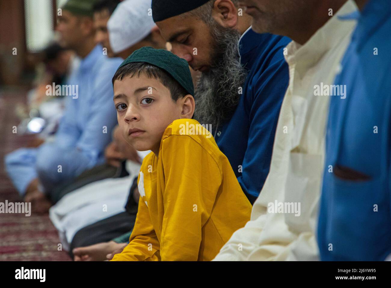 Kashmiri Muslim boy looks as men offering prayers during Eid-al-Fitr ...