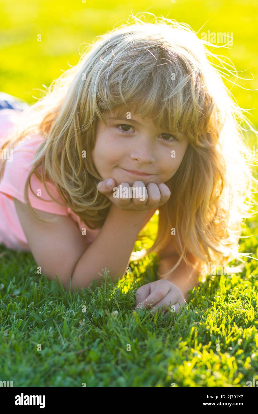 Summer child face. Smiling child boy with grass background. Summer kids ...