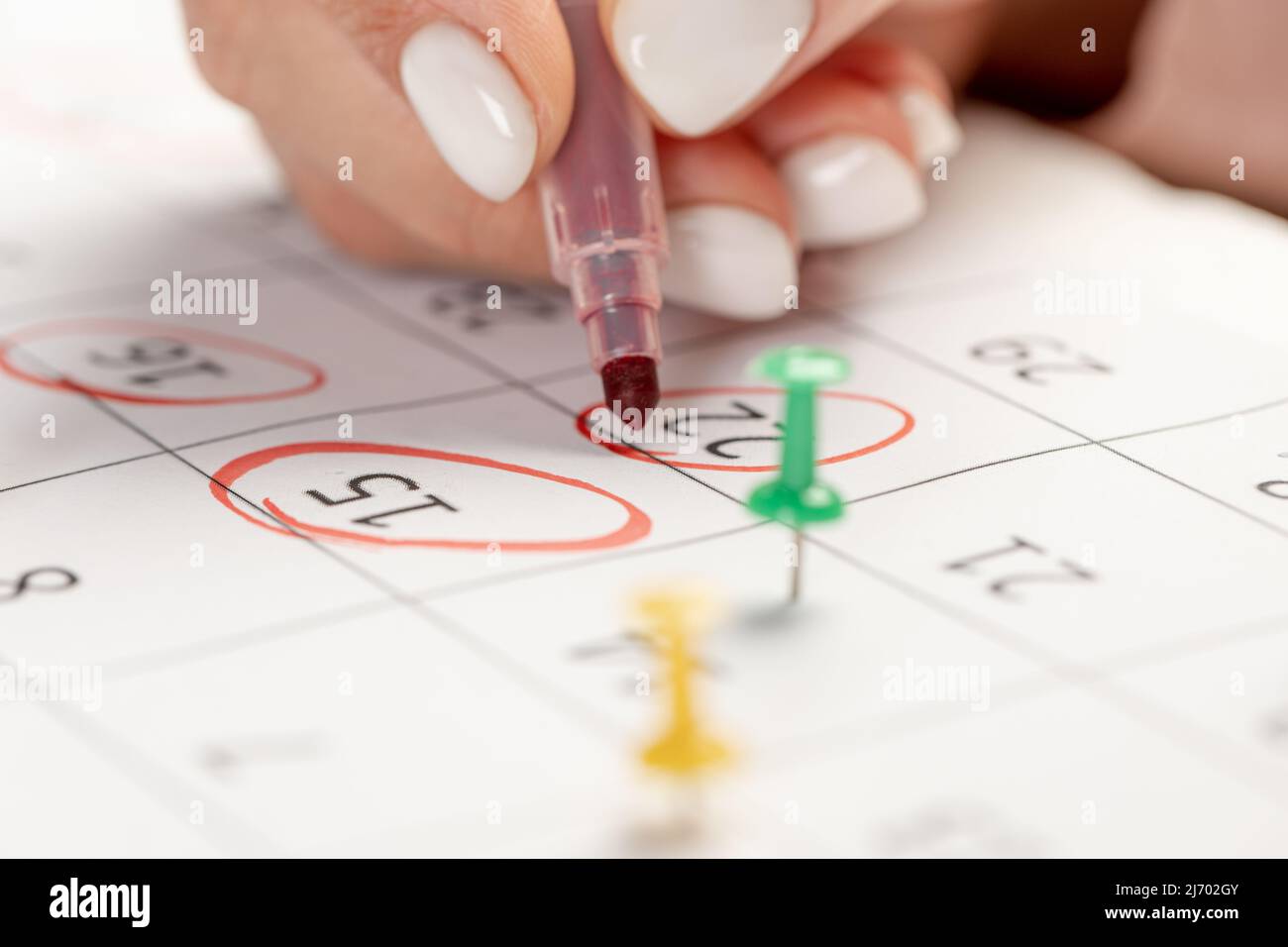 female hand marks with a red marker in the calendar notes an important ...