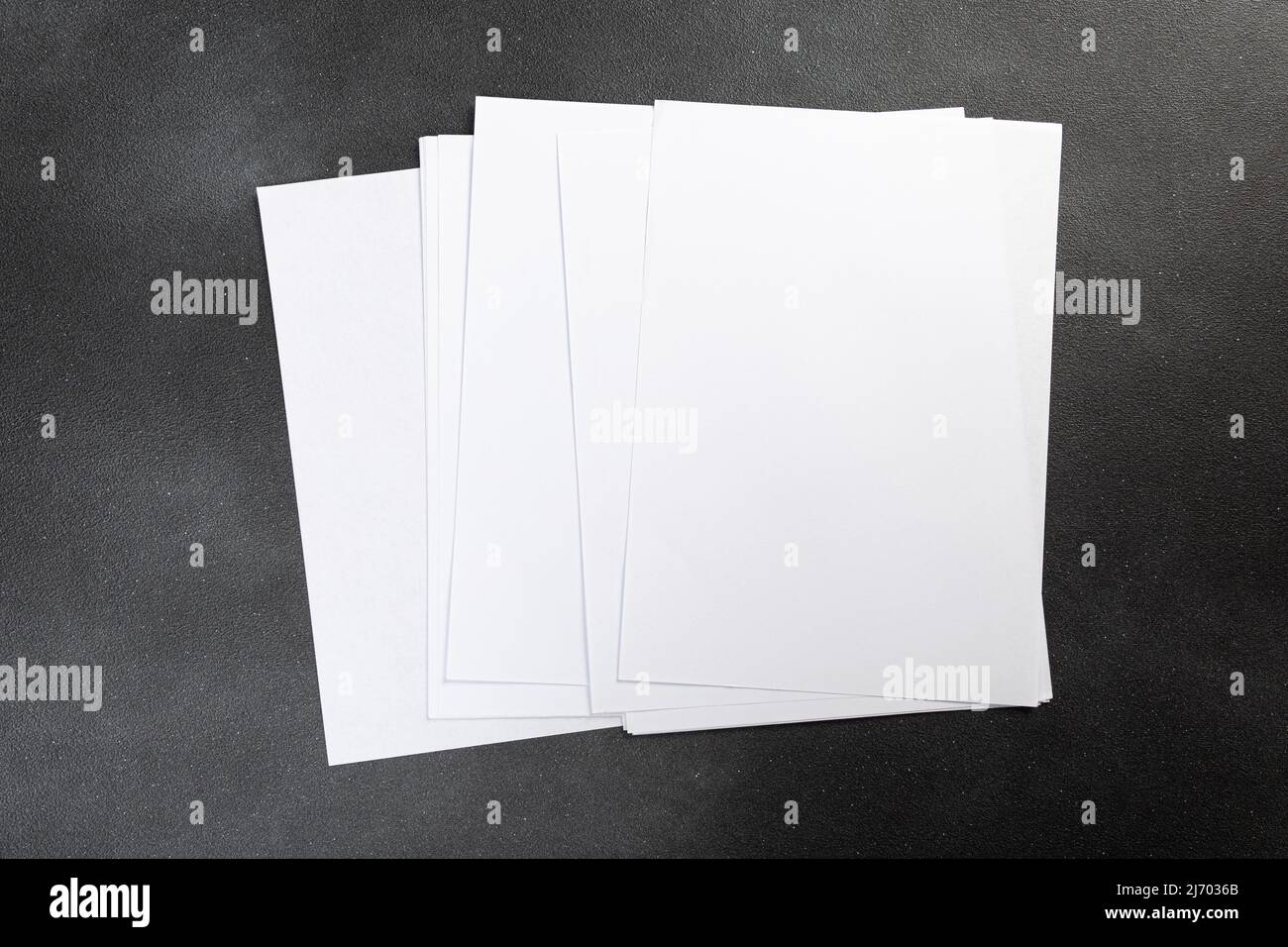 White business card sheet of paper a4 stack on a dark table. Clean ...