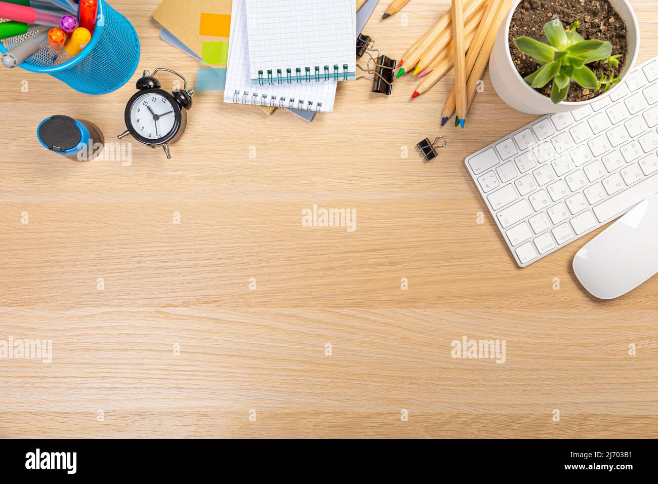 Wooden office table with laptop, coffee cup and supplies. Top view with ...
