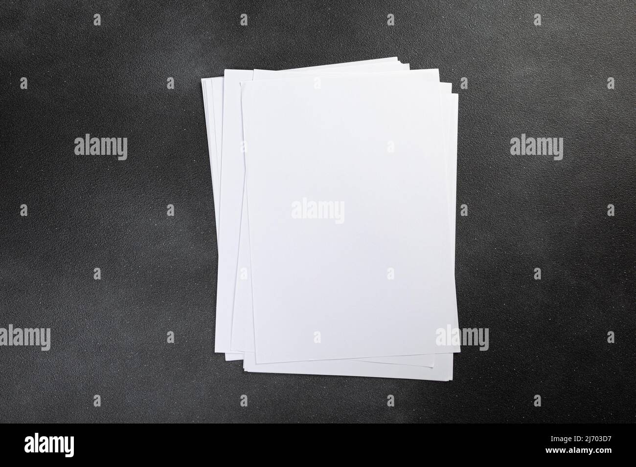 White business card sheet of paper a4 stack on a dark table. Clean ...
