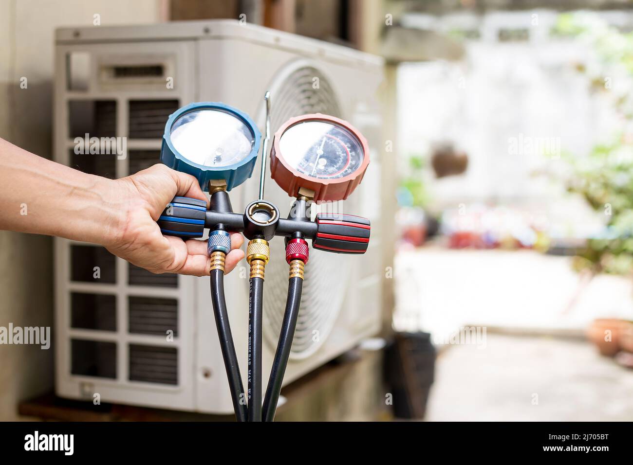 Air repair mechanic using measuring equipment for filling industrial ...