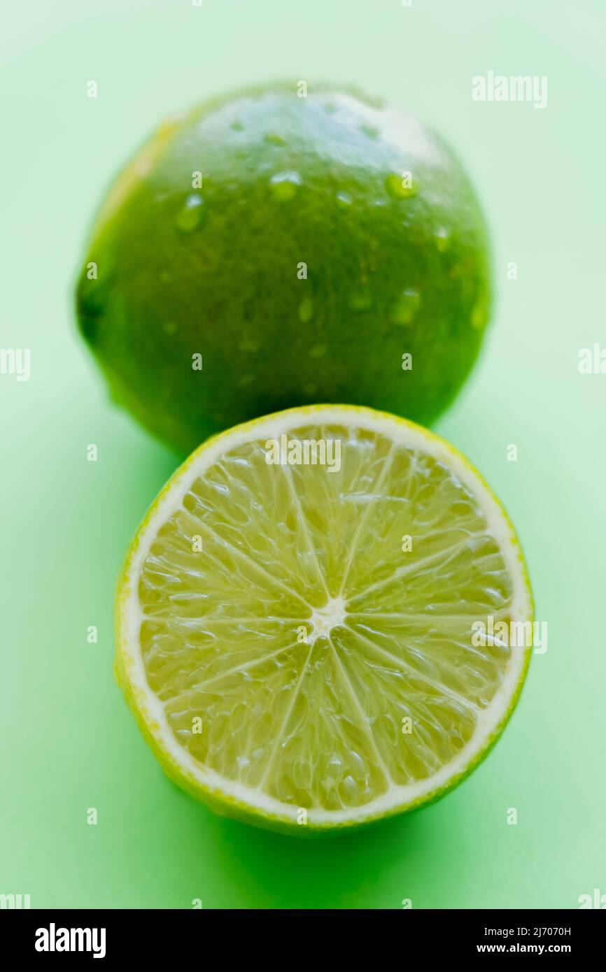 Close up view of juicy cut lime on green background Stock Photo - Alamy