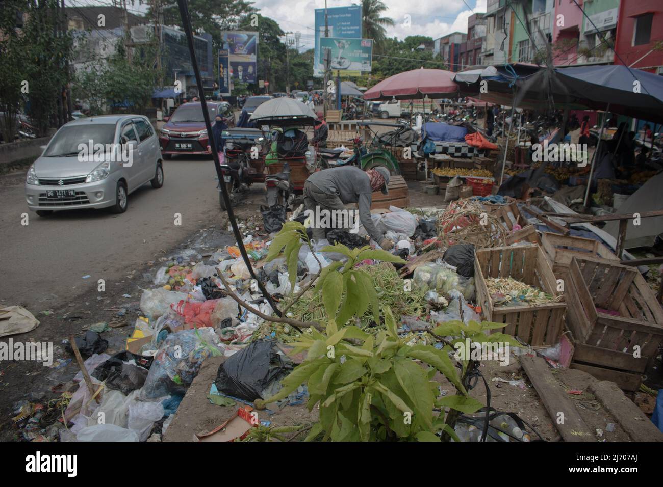 A number of piles of household waste are scattered on the side of the ...