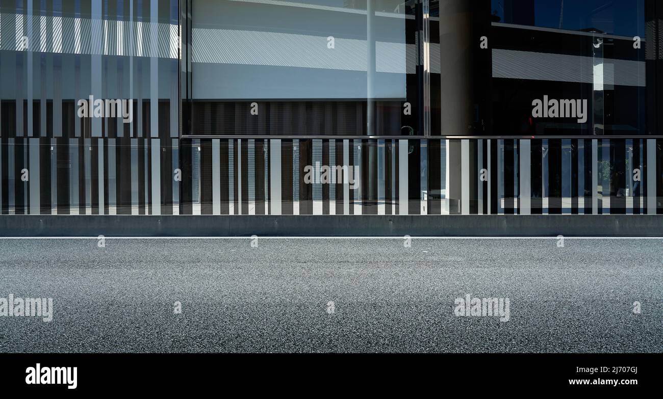 Side view of asphalt road with modern building exterior background ...