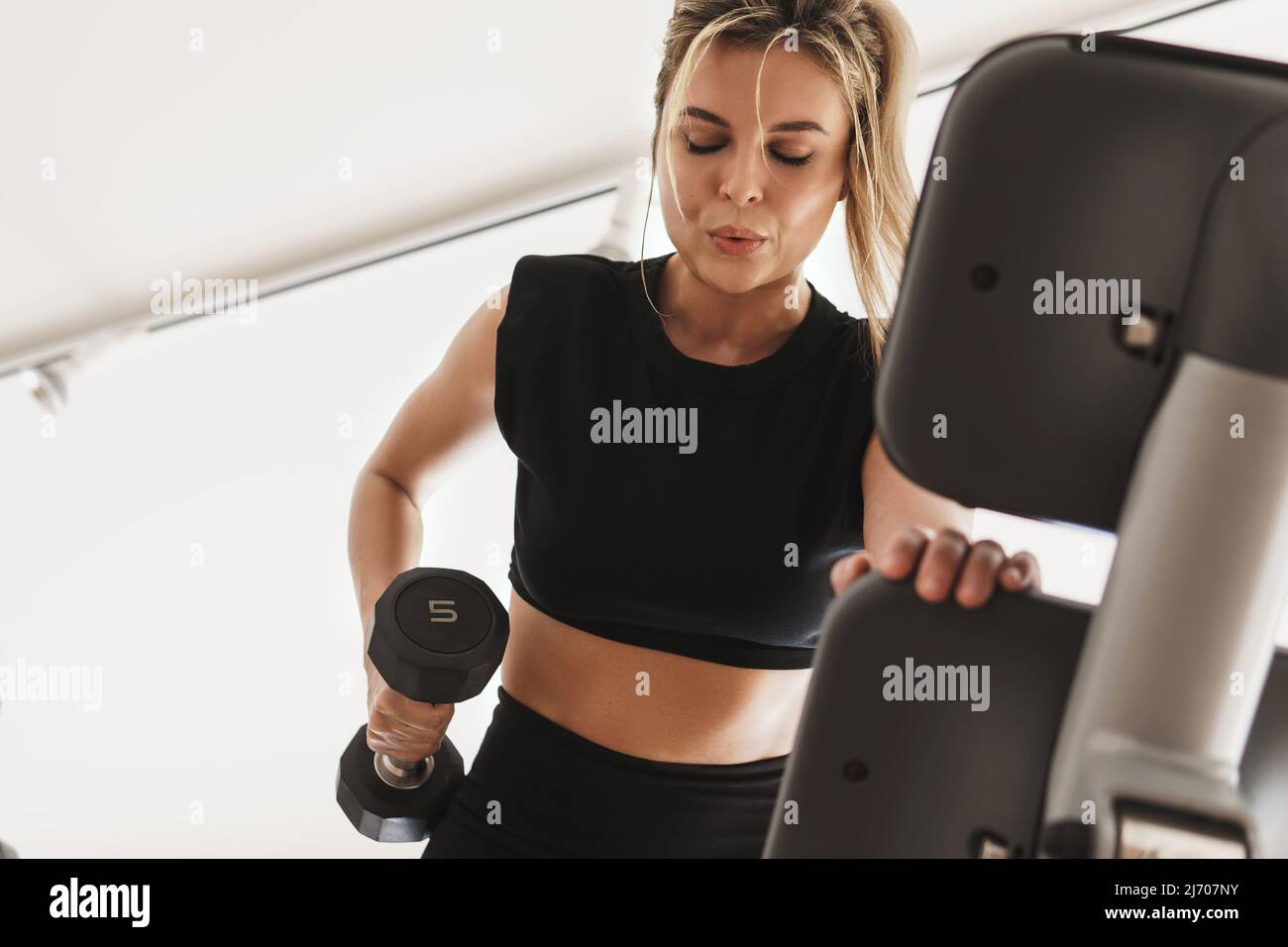 Athletic woman doing one arm dumbbell row exercise in the gym Stock ...