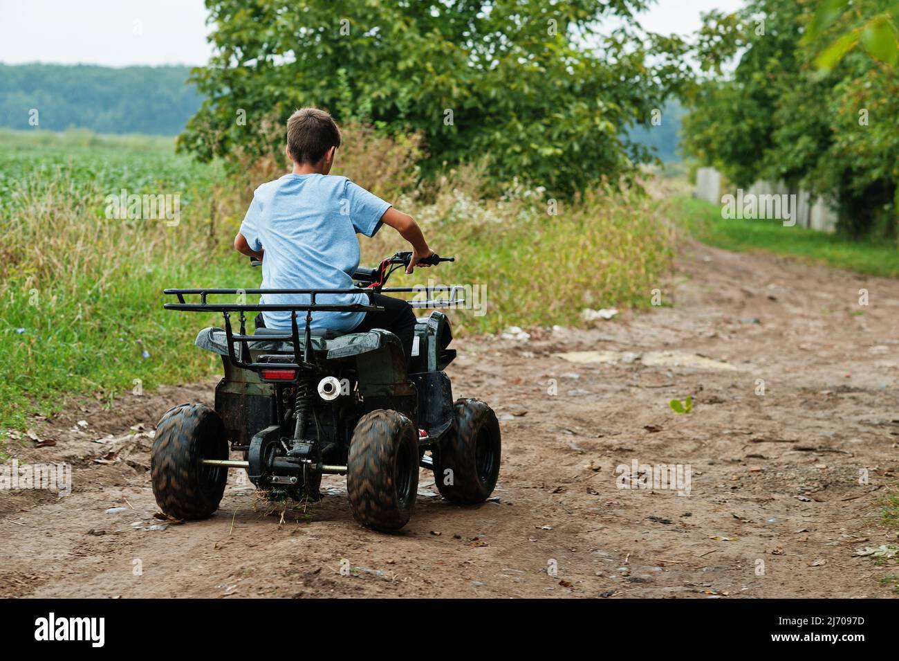 Boy drive four-wheller ATV quad bike Stock Photo - Alamy