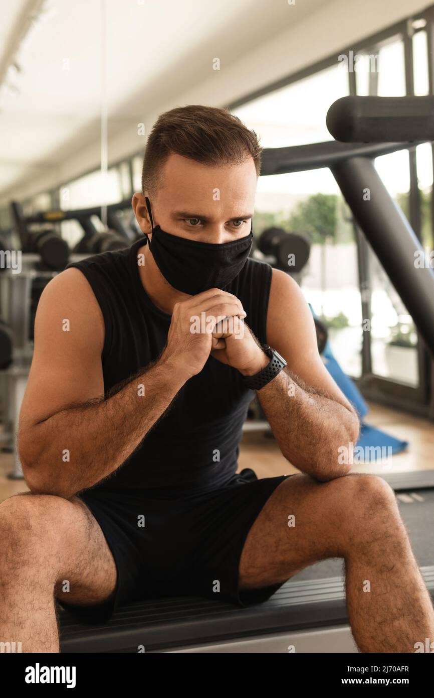 Young athletic man wearing a prevention face mask during his workout in ...