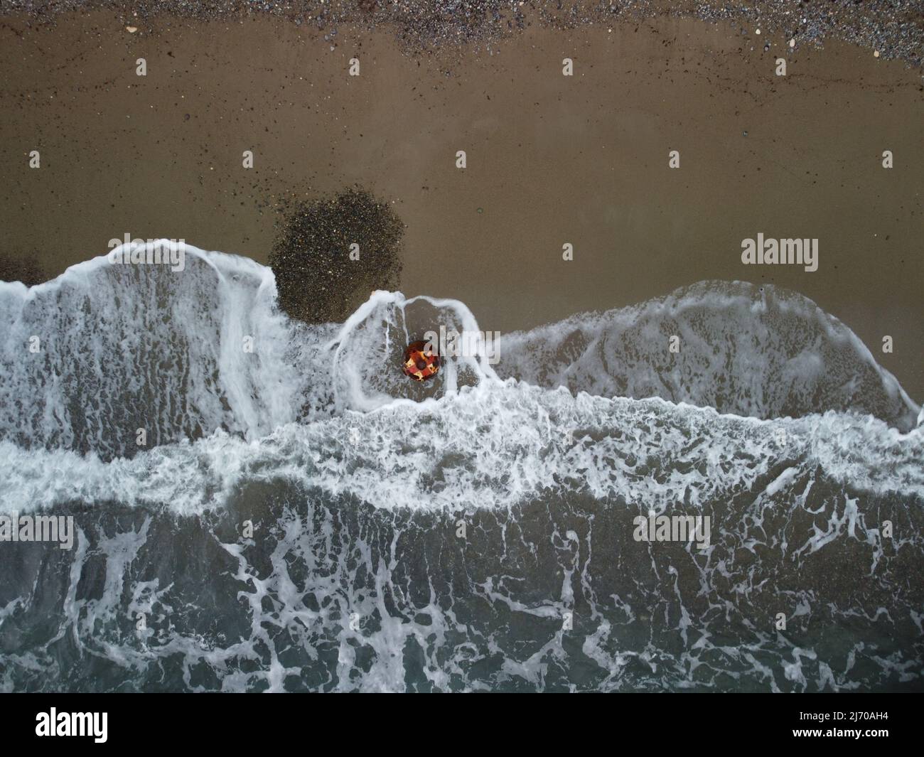 Aerial view from above on old rusty floating marine mine on the beach ...