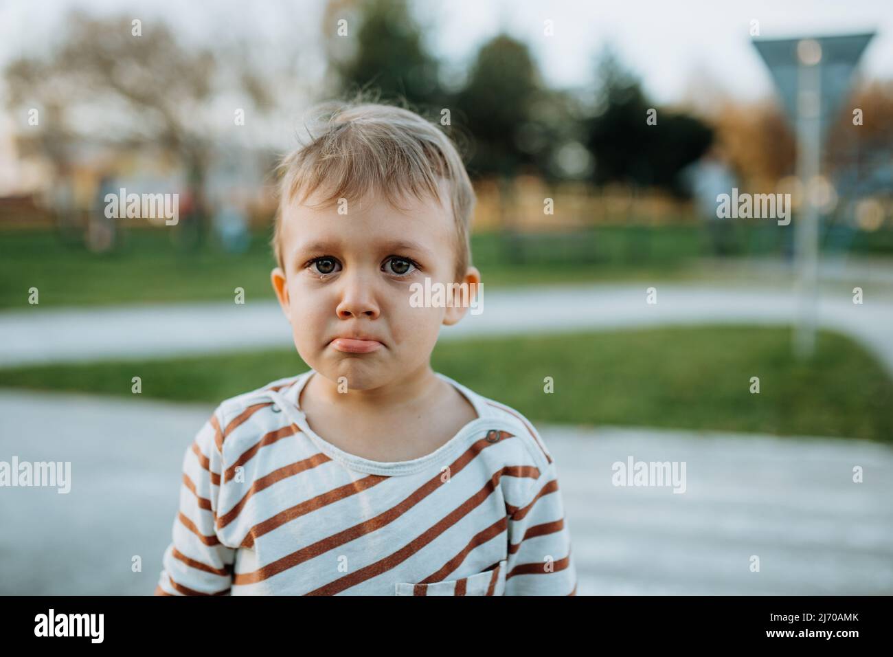 Sad little boy crying outside in park Stock Photo - Alamy
