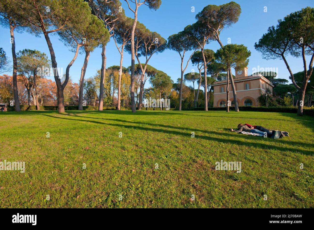 A young couple lying on the lawn in Villa Borghese Park, in the ...