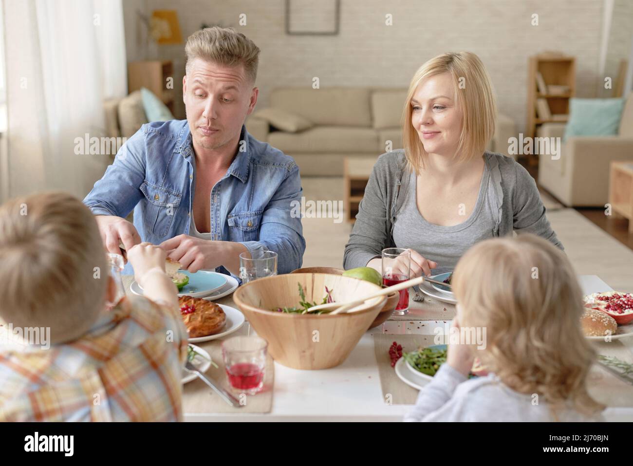 Happy Caucasian family with children sitting at dining table in living ...