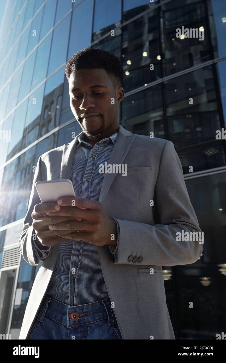 Low angle view of young confident African American businessman using ...