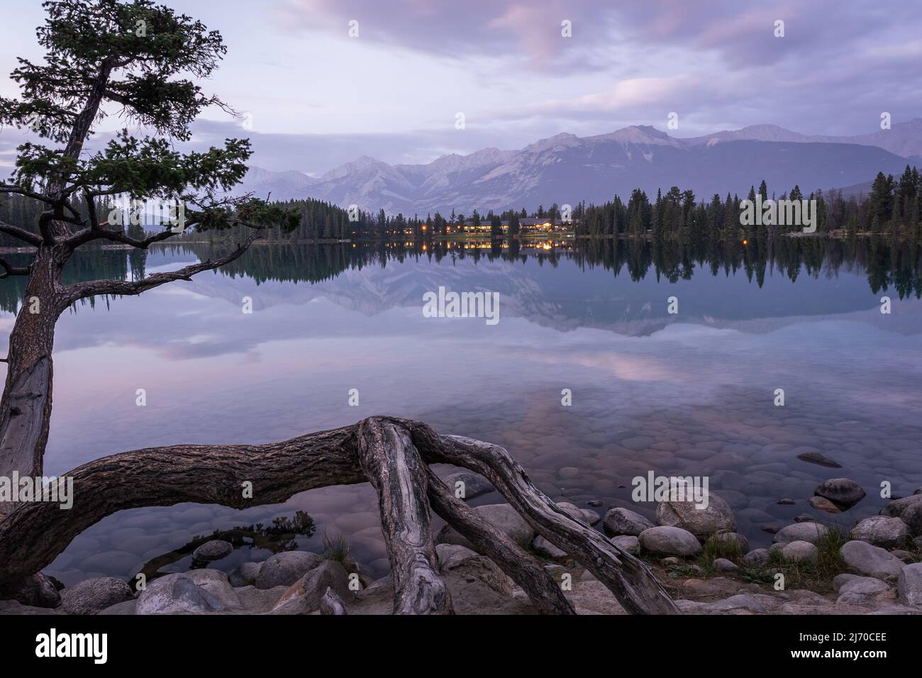 Colourful sunset on mirrorlike lake with mountains in backdrop ,wide ...