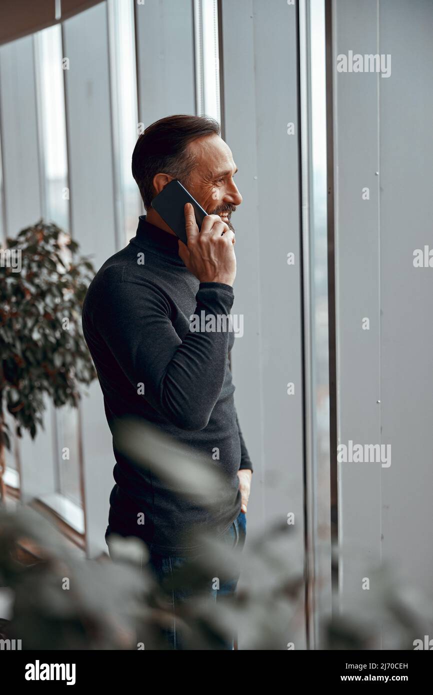 Man standing and talking on the phone Stock Photo - Alamy
