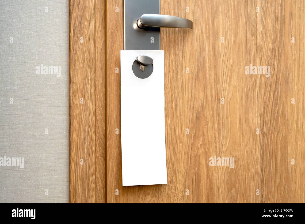 Paper blank label as mockup on door handle at the hotel. Wooden pine ...