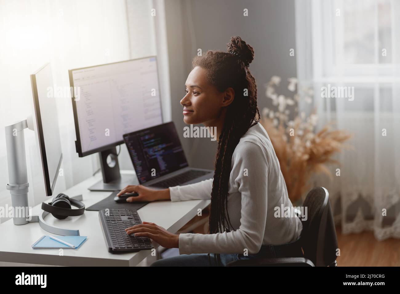 Side view of mixed-race young professional concentrated skilled web ...