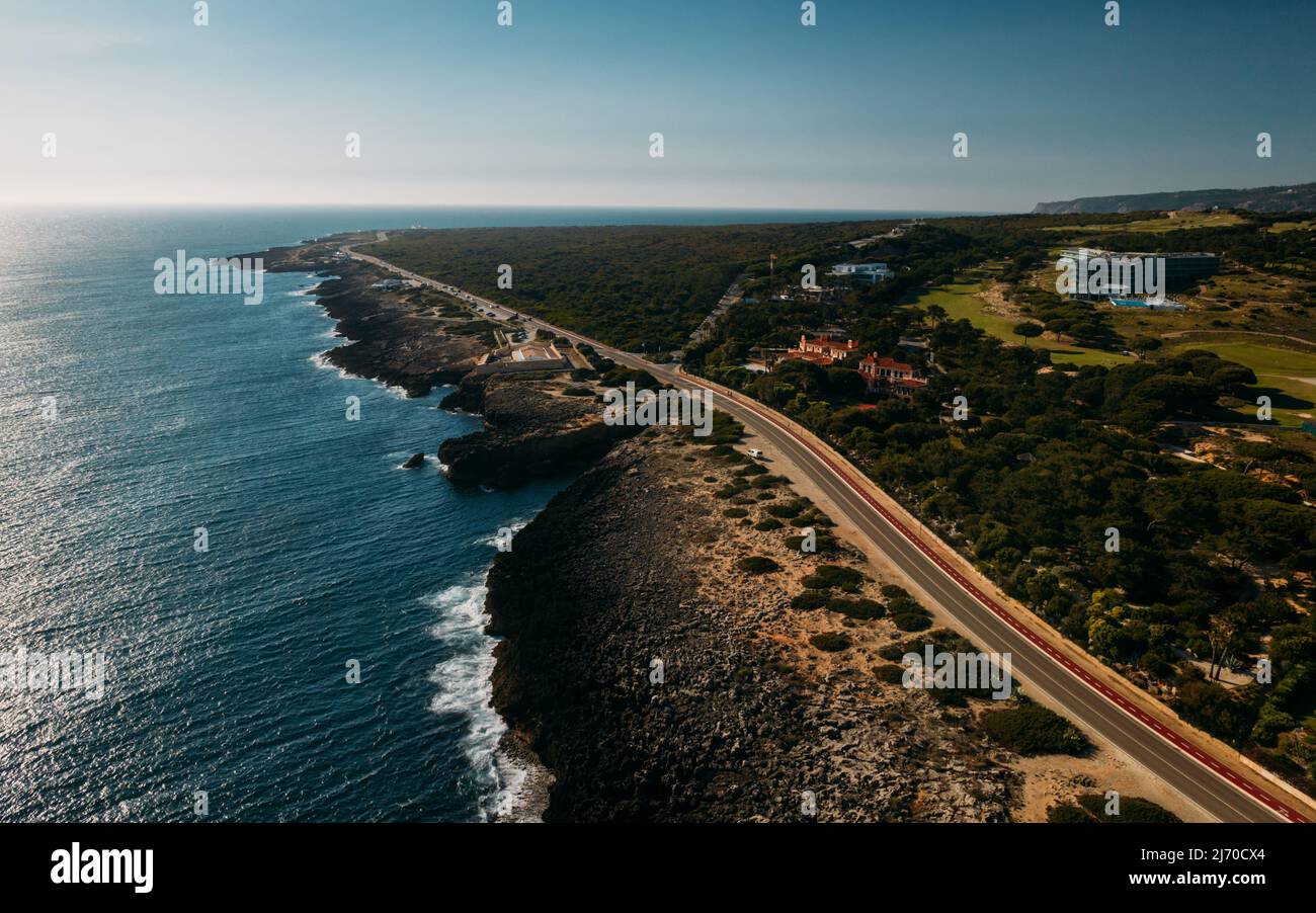 Aerial view top down view of of a straight road and rugged coastline at ...