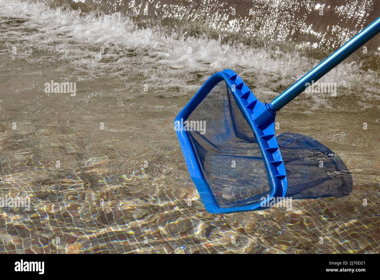 Cleaning pool, city fountain from garbage with special net. Clear water ...