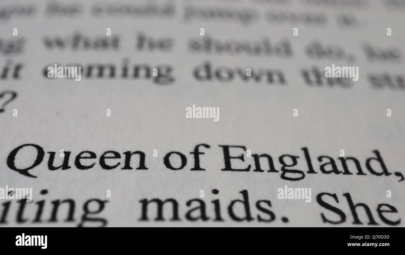 Queen of England text in open book page, selective focus, close up ...