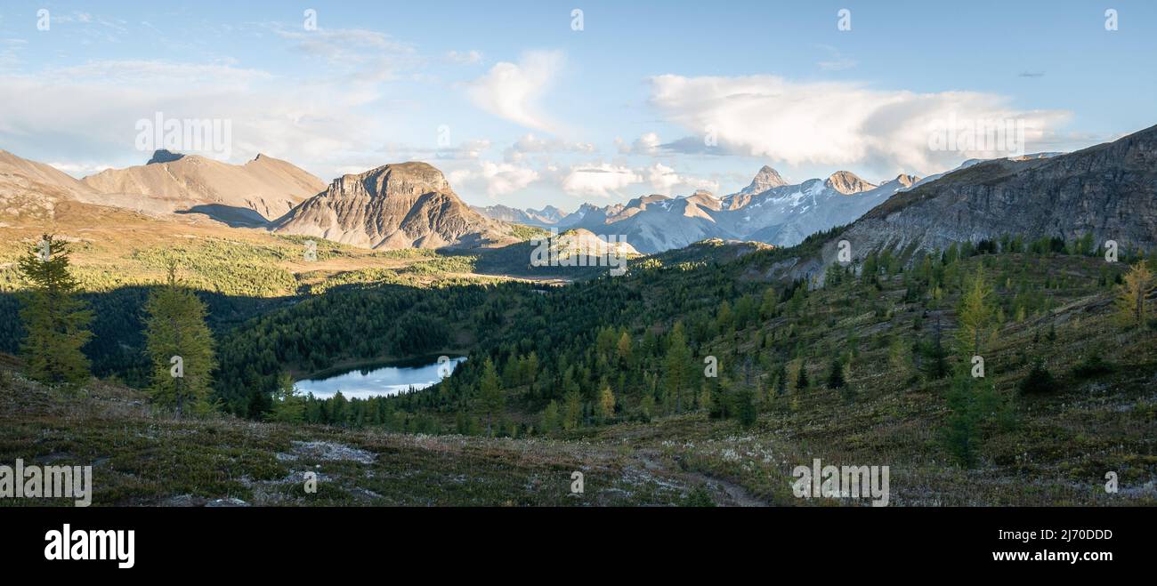 Beautiful alpine valley with forest, lake, mountains before sunset ...